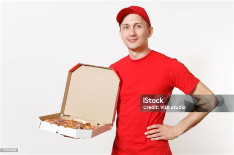 배달 빨간 유니폼을 입고 흰색 배경에 고립 된 사람을 웃 고 모자 티셔츠 택배 또는 골 판지 Flatbox에서 이탈리아 피자를 들고 딜러로 일하고 있는 남자 Pizzaman