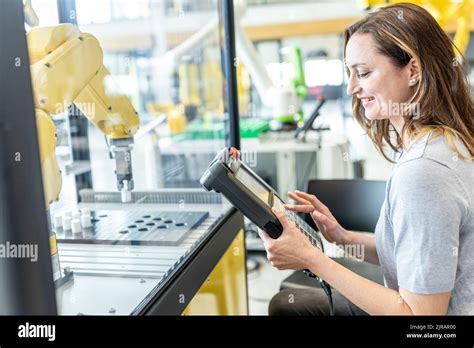 Woman In Factory Using Control Of Industrial Robot Stock Photo Alamy