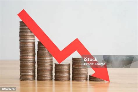 동전 쌓기 막대 차트와 빨간색 그래프가 나무 테이블에 흰 벽 배경으로 아래쪽으로 향하고 있다 손실에 대한 스톡 사진 및 기타