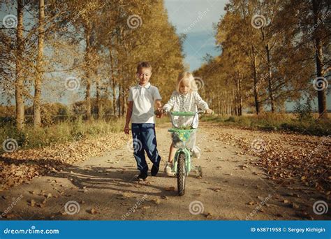 Мальчик играя с девушкой в проселочной дороге Стоковое Фото изображение насчитывающей девушка