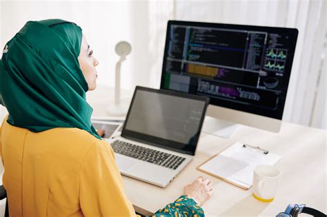 Seriousfemalesoftwareengineerworkingoncomputerandlaptopin