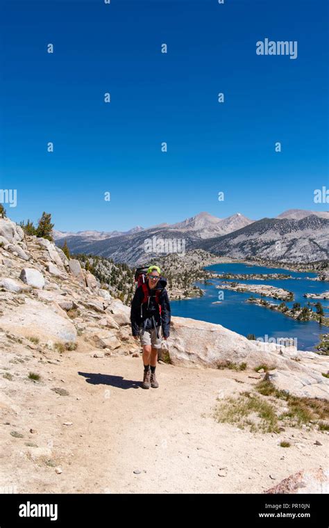 A Backpacker Ascends To Selden Pass With Marie Lake In The Background