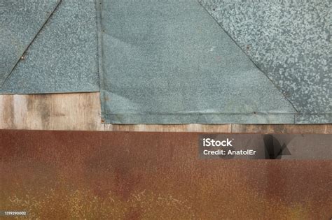 오래된 건물의 벽의 조각 다양한 철시트로 바이시다 합판의 바닥 층이 볼 수 있습니다 표면은 부분적으로 녹슬지 않습니다 배경