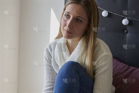 年轻的女孩躺在床上，一副四分之三的样子，姿态轻松，神情平静。