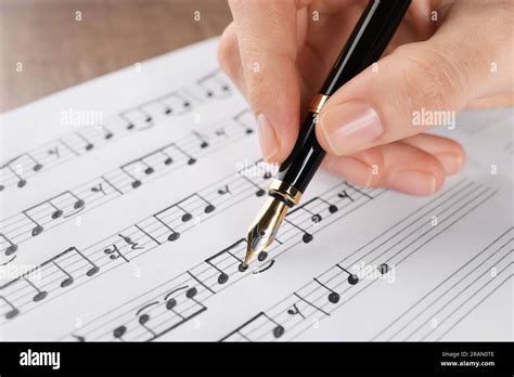 Woman Writing Musical Notes With Fountain Pen On Sheet Of Paper Closeup Stock Photo Alamy
