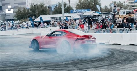 군중이 지켜보는 트랙에서 빨간색과 흰색 경주용 자동차 사진 Unsplash의 무료 자동차 이미지