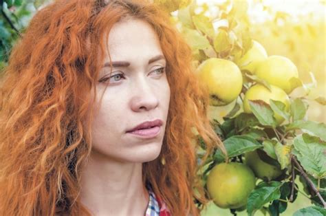 Premium Photo Charming Red Hair Woman Portrait In Apple Garden On The Background Of Twigs With