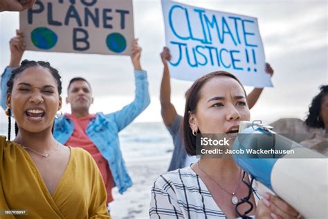 메가폰 기후 변화 아시아 여성이 해변에서 환경과 지구 온난화를 위해 시위하는 군중과 함께 시위합니다 지구를 구하고 집단 행동주의와 오염을 막기 위해 소뿔을 외치는 사람들