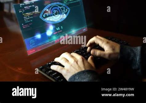 Hacker Typing On The Keyboard With Cyber Eye On Hologram Screen On Desk