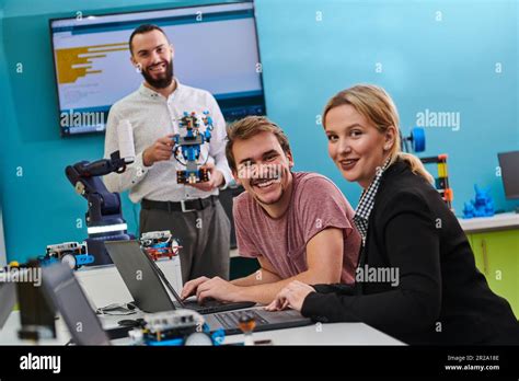 A Group Of Colleagues Working Together In A Robotics Laboratory Focusing On The Intricate