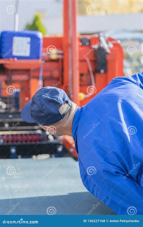 Worker Pressing Buttons On CNC Machine Control Board In Factory Vertical Photo Editorial Stock