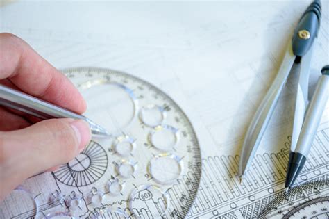 엔지니어의 손은 원형 눈금자가 있는 연필을 들고 인테리어 및 건축 디자인 개념을 위한 칸막이가 있는 백지에 건설 전 계획을 위한 주택 계획을 스케치합니다 건설 산업에 대한