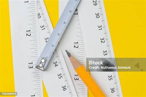 밝은 노란색 배경 길이 긴 또는 메이커 악기 및 도구 개념에 센티미터와 인치와 노란색 연필 및 흰색 측정 테이프 개념에 대한