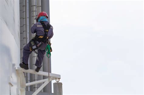 두께 저장 오일 및 가스 탱크 산업의 남성 작업자 로프 접근 높이 안전 검사 프리미엄 사진