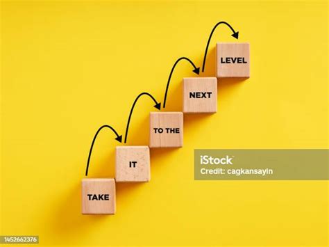 성장과 성공 개념을위한 비즈니스 경력 경로 메시지가있는 나무 블록 사다리는 화살표를 올려 다음 단계로 나아갑니다 Next Level English Phrase에 대한