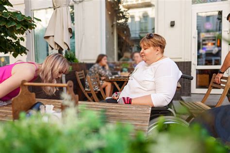 휠체어에 장애가 있는 어머니가 카페의 테이블에 앉아 딸과 이야기를 나누다 25 29세에 대한 스톡 사진 및 기타 이미지 25 29세 2명 50 54세 Istock