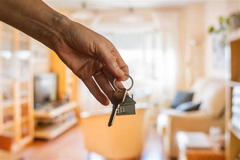 흐릿한 거실 앞에 집 모양의 열쇠 고리가 달린 열쇠를 손에 들고 새 집 부동산 투자 및 모기지 구입의 개념을 나타냅니다 가구에 대한 스톡 사진 및 기타 이미지 Istock