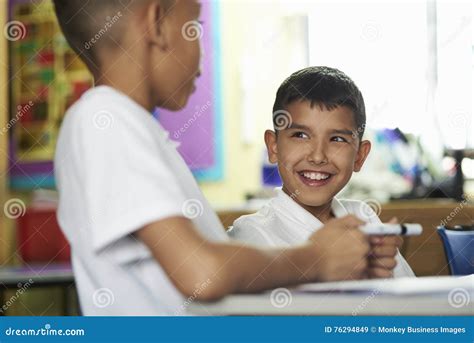 Close Up Of Two Primary School Boys Interacting In Class Stock Image