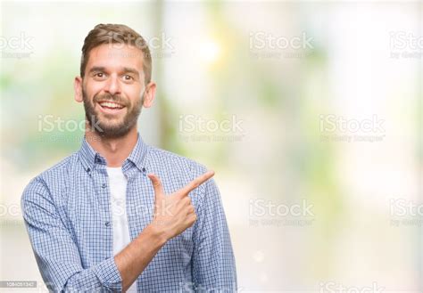 잘생긴 젊은이 손과 카메라 보고 얼굴에 행복 하 고 자연 식 가진 측까지 손가락으로 가리키는 얼굴의 미소와 쾌활 한 고립 된 배경 위에 흰색 T셔츠를 입고 T 셔츠에 대한