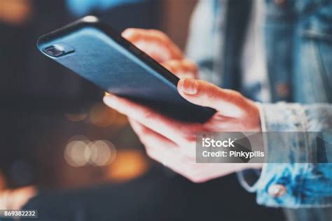 여성 손 현대 스마트폰 들고 밤에 터치 스크린에서 손가락을 가리키는의 근접 촬영 보기 수평 흐린 배경 Bokeh 효과입니다 사회 문제에 대한 스톡 사진 및 기타 이미지