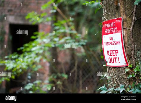 Keep Out Sign On UK Woodland Tree Warning Public To Keep Out No Trespassing Private Property