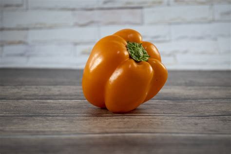 나무 테이블에 세 개의 오렌지 피망 그룹 사진 Unsplash의 무료 식물 이미지