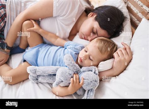 Mother And Son Sleeping On Bed Hugging Doll At Bedroom Stock Photo Alamy