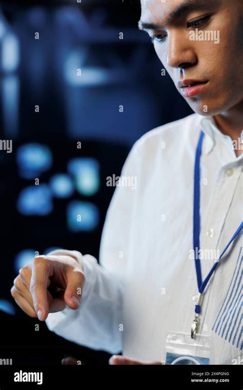 Engineer In Data Center Using Tablet To Prevent System Overload During Peak Traffic Periods