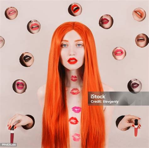 시체에 입술에서 키스와 함께 아름 다운 빨간 머리 모델 손에 빨간 매트 립스틱을 보유 하고있다 회색 바탕에 긴 머리 빨간 입술
