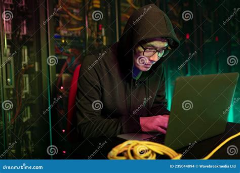 Asian Male Hacker Using A Laptop In Computer Server Room Stock Photo Image Of Mature