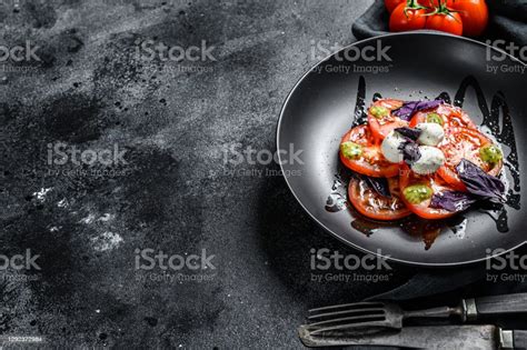 이탈리아 전통 카프리스 샐러드 체리 토마토 모짜렐라 치즈 바질 페스토 소스 검은 색 배경 맨 위 보기입니다 복사 공간 0명에