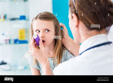 Doctor Instructing A Girl On How To Use An Asthma Inhaler Stock Photo Alamy