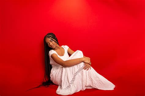 긴 머리띠를 한 하얀 옷을 입고 침착하게 앉아 있는 아름다운 젊은 흑인 여성 땋은 머리에 대한 스톡 사진 및 기타 이미지