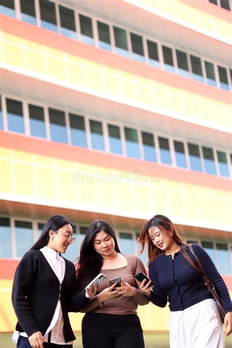 Three Beautiful Young Asian Girls Using Smartphone Chatting On The