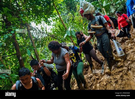 Haitian Migrants Climb Down A Muddy Hillside Trail In The Wild And
