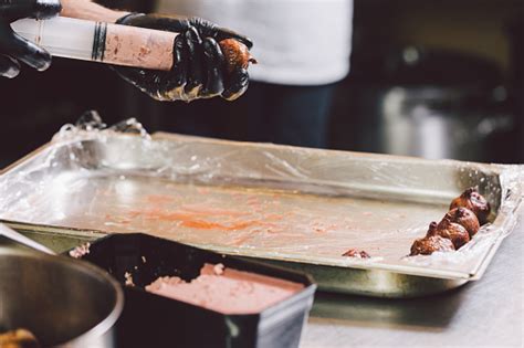 테마 요리 손을 닫습니다 부엌에서 검은 유니폼과 라텍스 장갑 젊은 백인 남자 레스토랑은 지상 쇠고기를 준비 하 고 주사기와