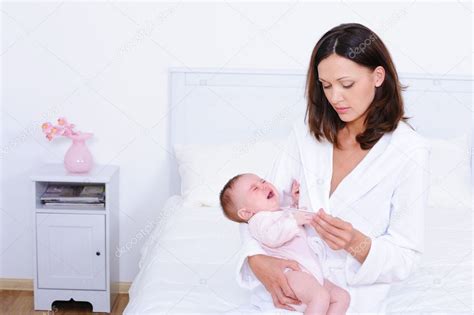 Woman Measuring Temperature To Her Son Stock Photo Valuavitaly