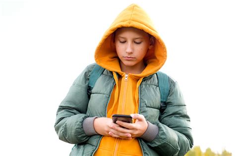 초상화는 쾌활한 십대 채팅 스마트폰입니다 소년은 야외에서 노란 두건을 쓰고 있다 12 13세에 대한 스톡 사진 및 기타 이미지 12 13세 Brand Name