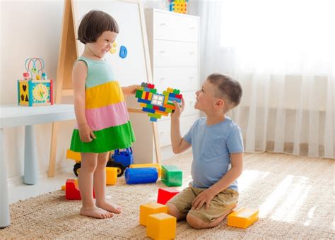Un Niño Y Una Niña Sostienen Un Corazón Hecho De Bloques De Plástico