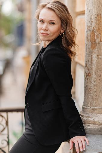 오래된 건물의 발코니에 검은 양복을 입은 아름답고 자신감 있는 여성 개념에 대한 스톡 사진 및 기타 이미지 개념 건물 외관