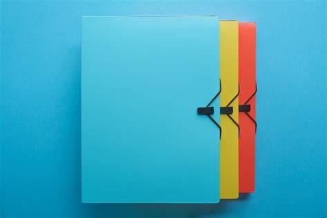 Premium Photo Top View Of Multicolored Paper Binders In Row On Blue