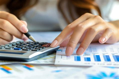 Female Accountant Calculating Business Data Using Pen And Calculator In