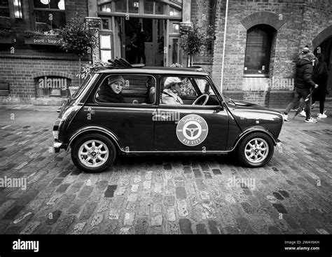 A Woman Sits In The Back Of A British Mini Car On A Tour Of Londons Smaller Streets In England