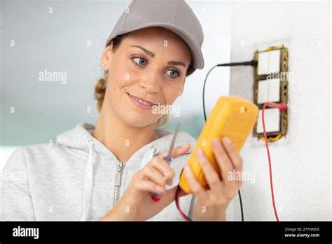 Female Electrician Testing A Wall Socket Stock Photo Alamy