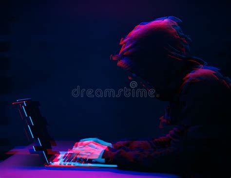 Hacker In The Hood Working With Laptop Typing Text In Dark Room Image With Glitch Effect Stock