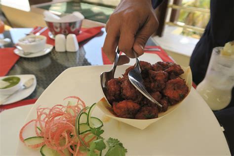 포크와 숟가락을 사용하여 웨이터가 제공하는 음식과 인도 레스토랑 식사에서 먹는 이미지 매운 튀김 치킨 파코라 레시피 테이블에 비