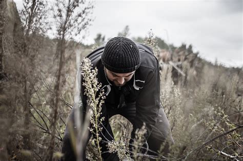 도끼를 든 벌목꾼은 쓰러진 나무 줄기 위의 숲 가장자리에 있는 들판에 기대어 있었습니다 한 남자가 집안의 스토브에 장작을 준비합니다 도시 밖의 삶의 개념 근육질 체격에 대한