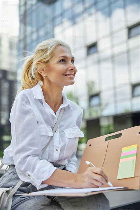 비즈니스 옷을 입고 종이 폴더에 메모를 하는 잘 생긴 사업가의 측면 모습 초상화 사진 Unsplash의 활동적인 라이프 스타일 이미지