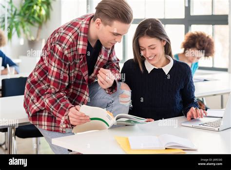 Friendly Student Helping His Classmate By Explaining And Showing Stock