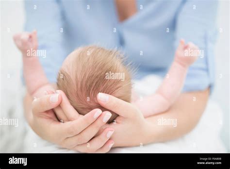 Mother Cradling Baby In Arms Stock Photo Alamy